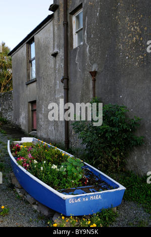 Unusual flower pot bed in the garden. A flower bed out of old plastic ...