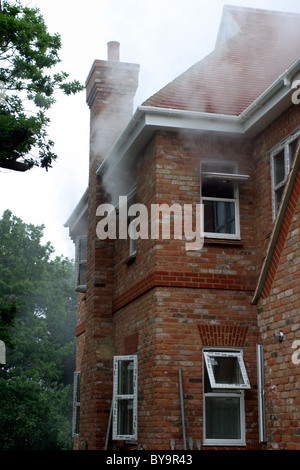 House on fire with flames coming out the windows Stock Photo - Alamy