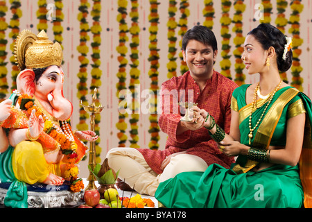 Couple performing a pooja Stock Photo - Alamy