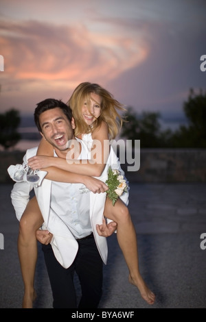 Groom carrying his bride at sunset Stock Photo - Alamy