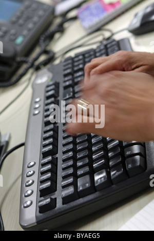 Blurred hands typing on computer keyboard Stock Photo - Alamy