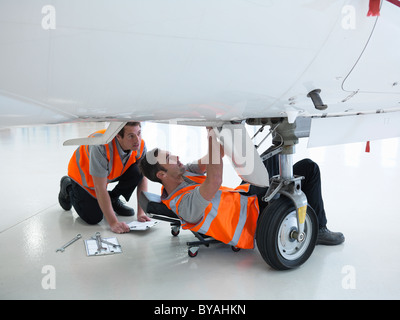 Engineers working on jet aircraft Stock Photo - Alamy
