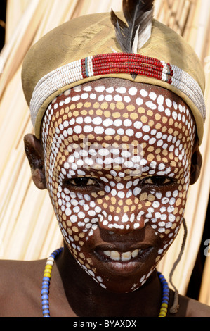 Traditionally painted boy from Arbore tribe standing in dry environment ...