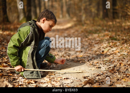 Boy writing in sand with stick, Grand Sand Dunes National Park ...