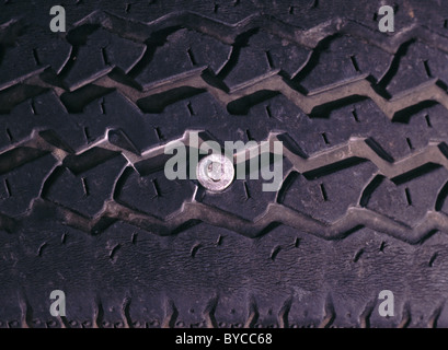 Nail hole in flat tire Stock Photo - Alamy