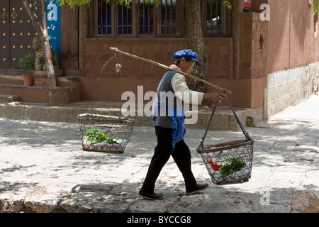 China, Chinese Woman Carrying A Pole Over Her Shoulder With Baskets Of ...