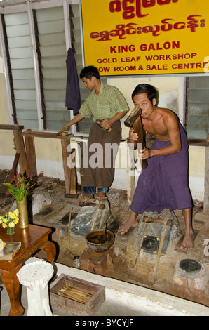 Myanmar (aka Burma), Mandalay. Gold leaf workshop, men beating gold ...