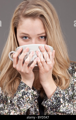 Blonde woman drinking something hot isolated on white background Stock ...