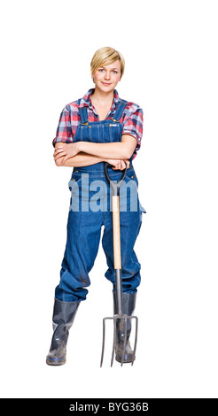 Portrait of positive woman farmer with pitchfork in cowhouse Stock ...