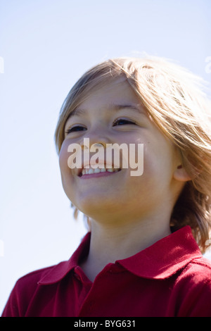 Portrait smiling blond boy bright blue eyes stands among crowd outdoor ...