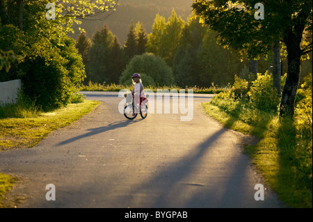 One caucasian children rides bike road in autumn park. Little girl ...