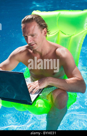 Man sitting on inflatable raft and working on laptop Stock Photo - Alamy
