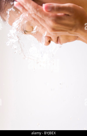 Side profile of woman washing her face in sink with her husband ...