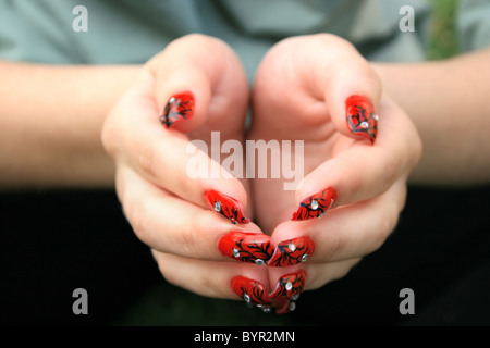 Open female hands with red polished nails, fingers spread in a relaxed ...