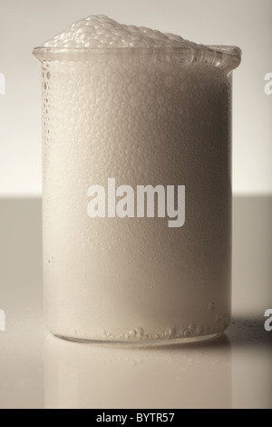 effervescent table dropped in a laboratory beaker full with water ...