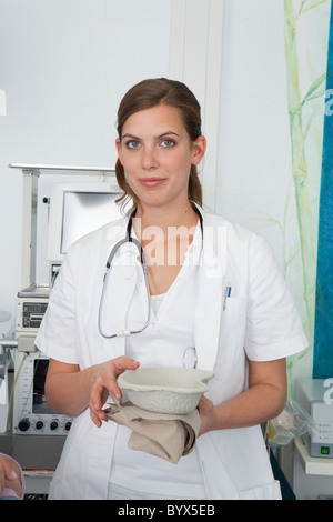 Nurse holding bowl with medical instruments Stock Photo - Alamy