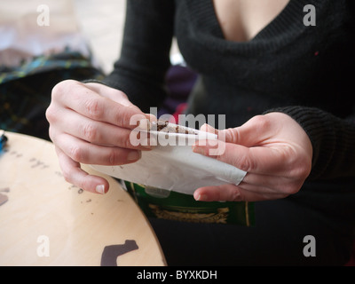 young woman makes a roll up cigarette Stock Photo - Alamy