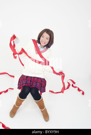 Young woman wrapping ribbons around her body Stock Photo - Alamy