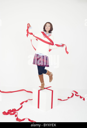 Young woman wrapping ribbons around her body Stock Photo - Alamy