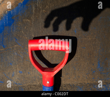 Spade and a shadow image of a hand Stock Photo - Alamy
