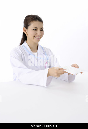 Pharmacist holding out an envelope for drug Stock Photo - Alamy
