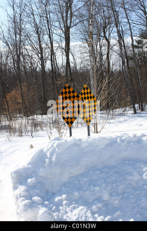 A black and yellow checkered warning sign at the end of a road Stock ...
