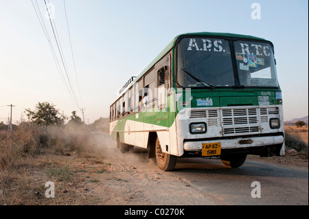 Indian bus traveling along a rural indian village road with teenage ...