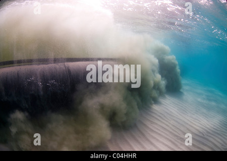 Workers laying a brine discharge pipe from a desalination plant on the ...