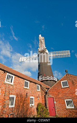 A traditional old English windmill and farm house cottage nestling in ...