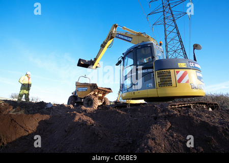 Mechanical diggers excavating earth on a building site Stock Photo - Alamy