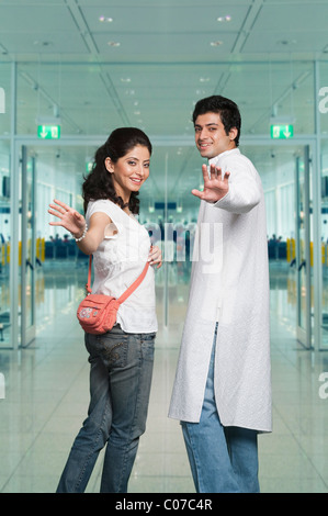 Two Asian men waving at camera while streaming online content with ...