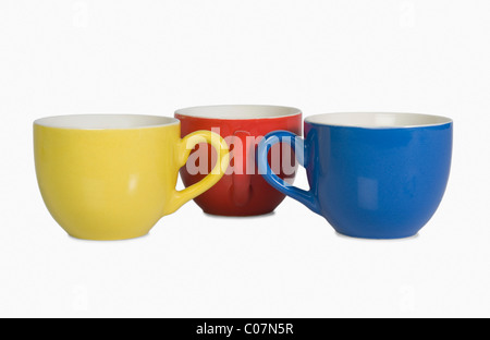 Three multi-colored cups of tea on a wooden table hazelnuts and walnuts ...