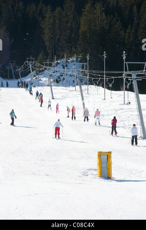 Skiers and snowboarder being pulled on a t-bar tow at Bansko ski resort ...