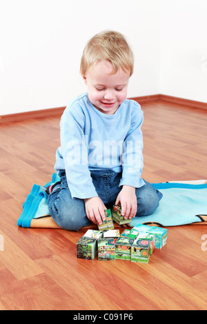 Adorable toddler playing with construction blocks sitting on table at ...