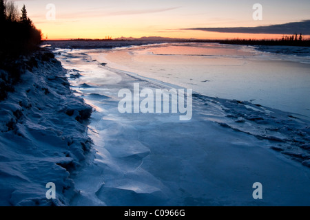 View of frozen ice along the Knik River at sunset, Southcentral Alaska ...