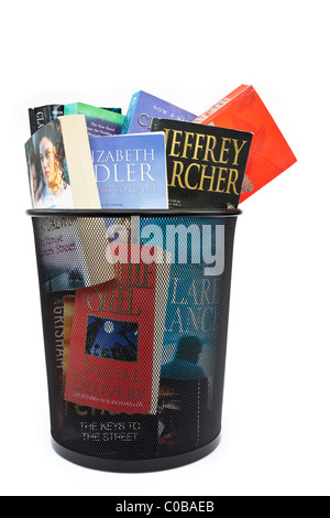 Paperback books thrown away in a wastepaper bin to illustrate concept ...