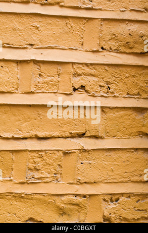 A texture of mustard yellow brick wall, showing the vertical ...