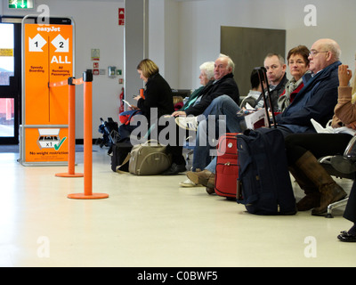 passengers sitting waiting queueing at easyjet gate at Belfast ...