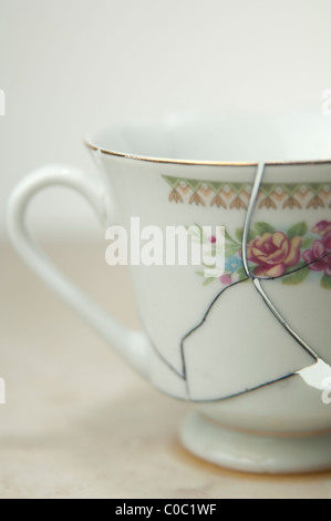 Clumsily repaired leaky teacup with cracks Stock Photo - Alamy