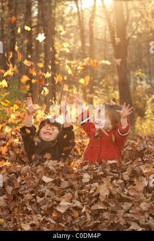 Kids playing in the fall leaves Stock Photo - Alamy