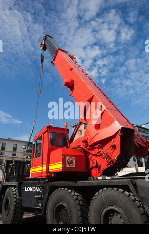 Mobile truck-mounted crane lifting heavy concrete building materials on ...