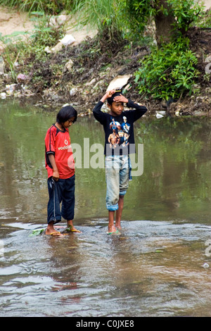 Two Burmese teenage boys are bathing in a dirty and polluted river in ...