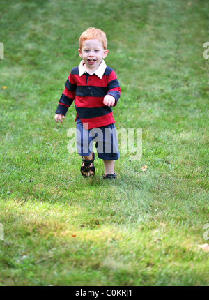 Happy child with red t-shirt playing in the garden Stock Photo - Alamy