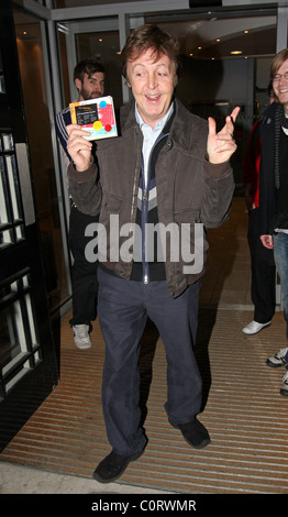 Paul McCartney holds up the new album from his band 'The Fireman' as he ...