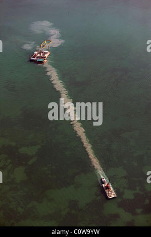 aerial above dredge barges and tug boats dredging the Port of Oakland ...