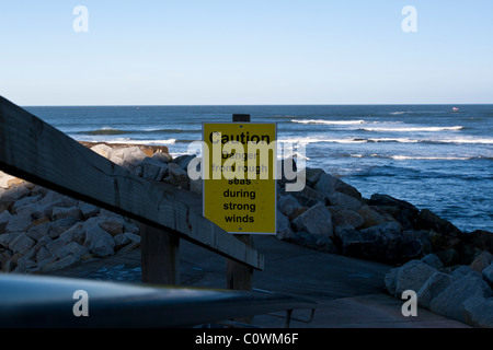 Caution sign about rough seas at Whitby Harbour Wall, North Yorkshire ...