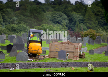 Digging grave with mechanical digger Mini JCB in grave yard Stock Photo ...