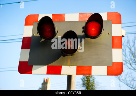 Level crossing with warning lights flashing and barriers down on the ...