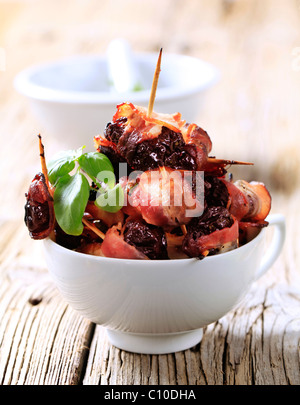 Roasted dried plums wrapped in bacon Stock Photo - Alamy