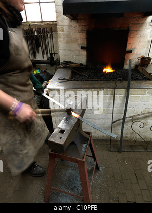 Blacksmith forge with flames on hot coals and tools in the fire to ...